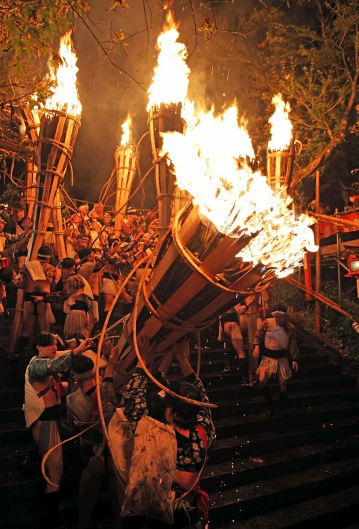 The flames of large torches dance in the night sky at the ''kurama fire ...